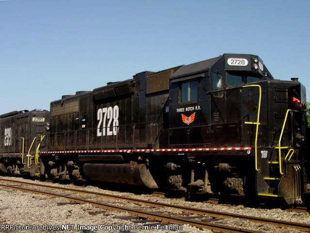 Three Notch Railroad GP38 #2728 sits in the clear as a contractor with a tie gang inserts new ...